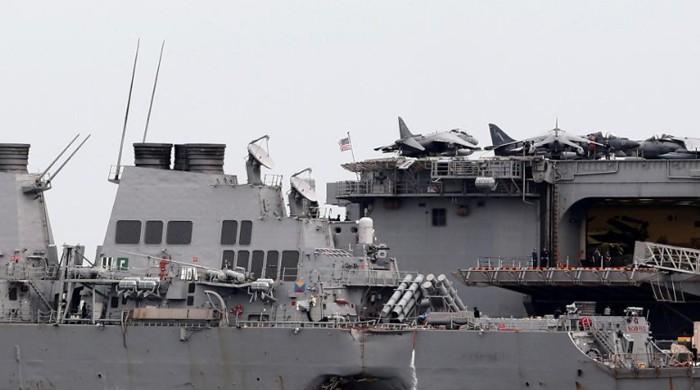 US divers find body remains in hull of damaged destroyer