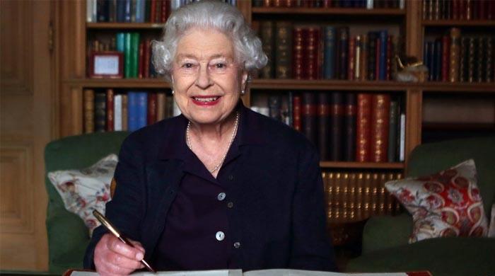 Queen Elizabeth signs her message to the Commonwealth
