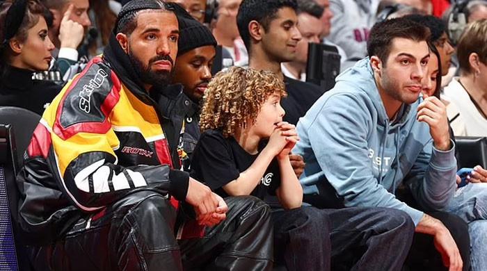 Drake gives a warm hug to son Adonis during NBA game